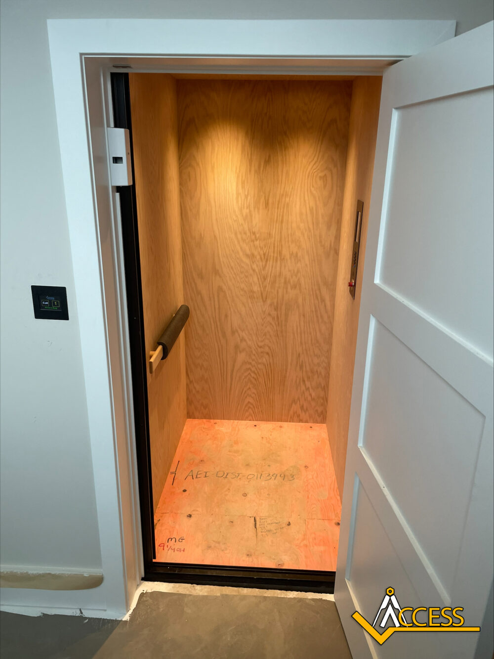 An open residential elevator with unfinished wooden walls and floor ...