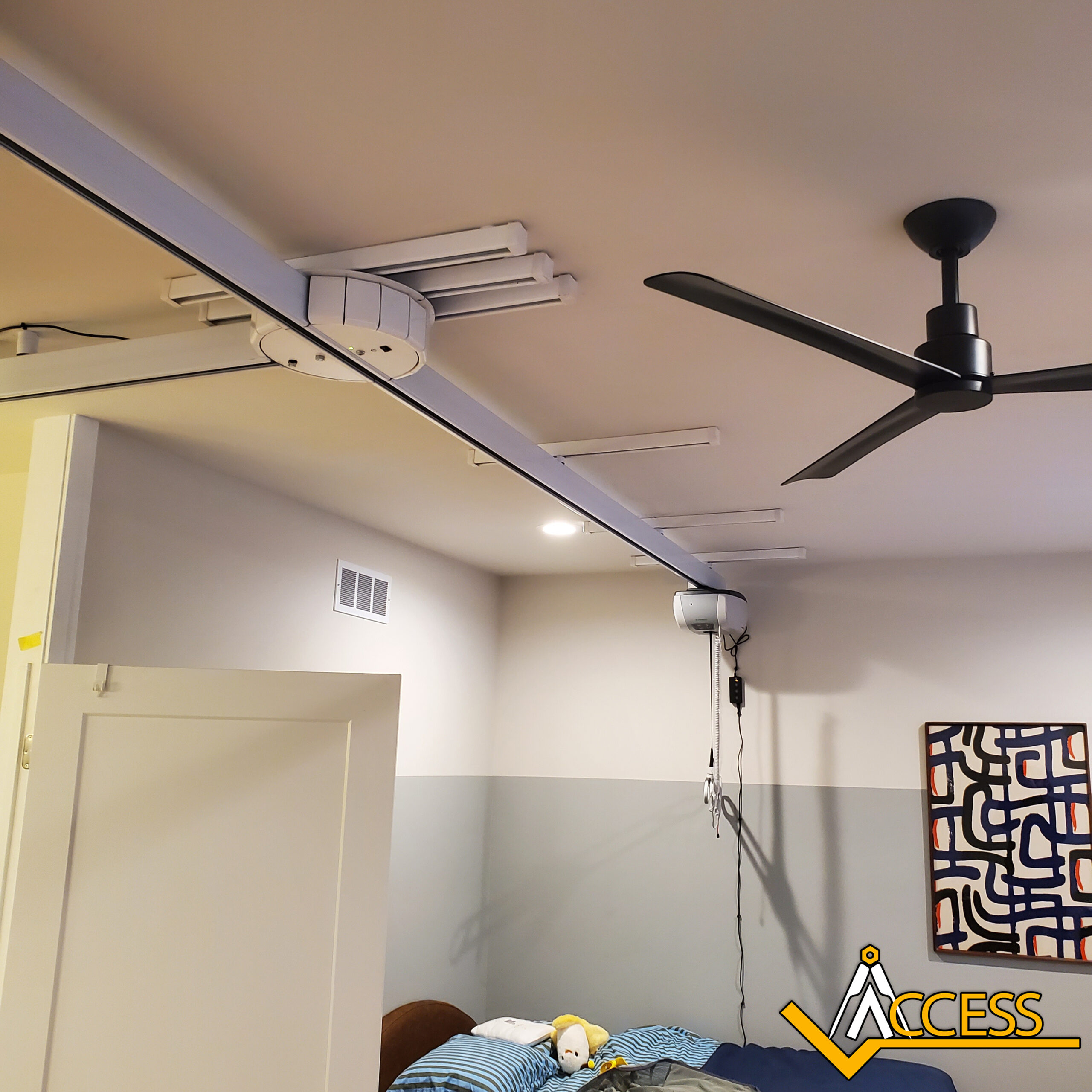 A ceiling-mounted overhead lift system runs along the ceiling of a ...